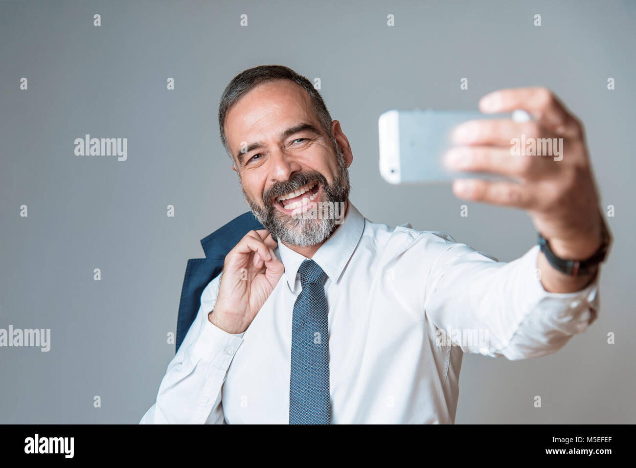 Happy and cheerful business man taking a selfie, posting image on ...