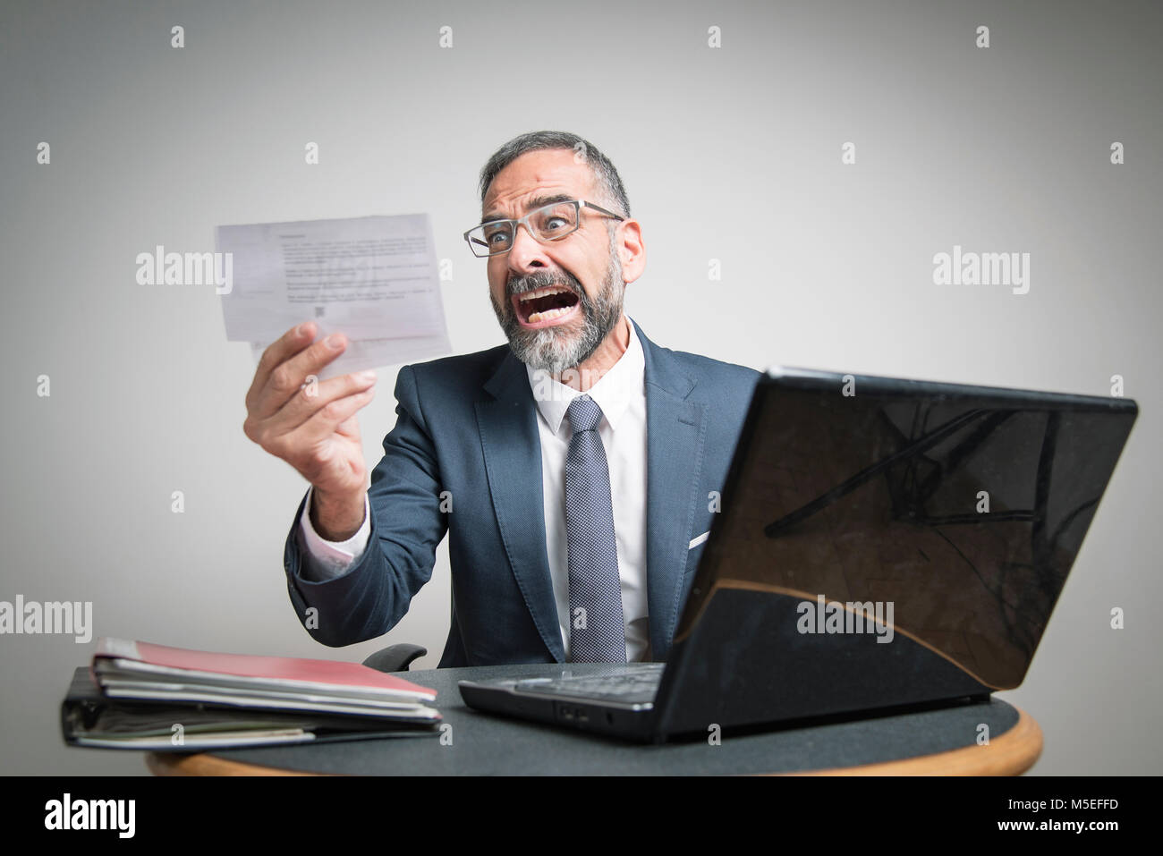 Furious business man shocked and angry with expensive bills he receives ...