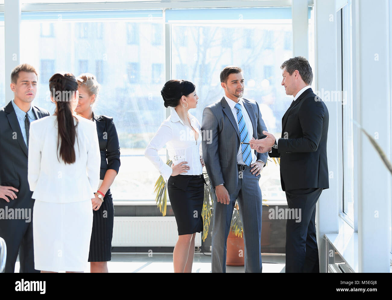 group of business people talking,standing in the lobby of the office ...
