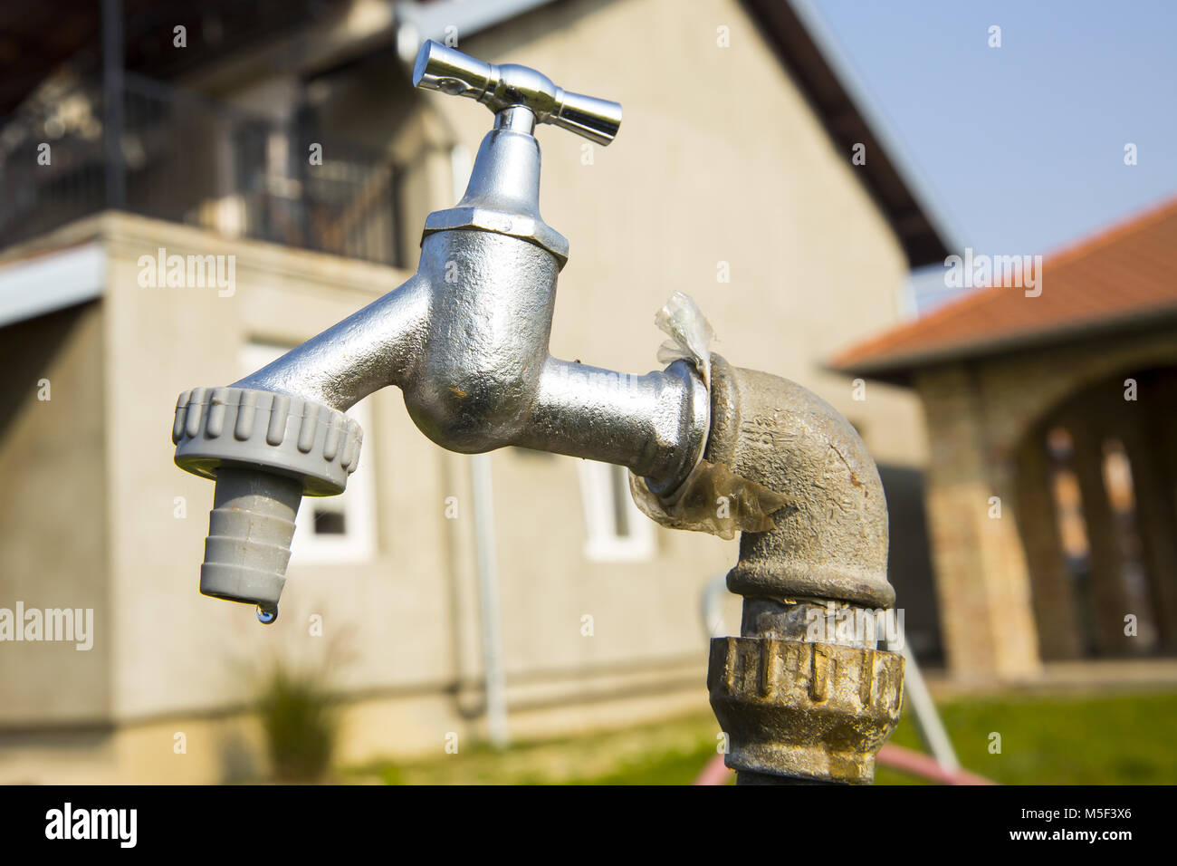 Wasting water - water drop from water tap Stock Photo - Alamy