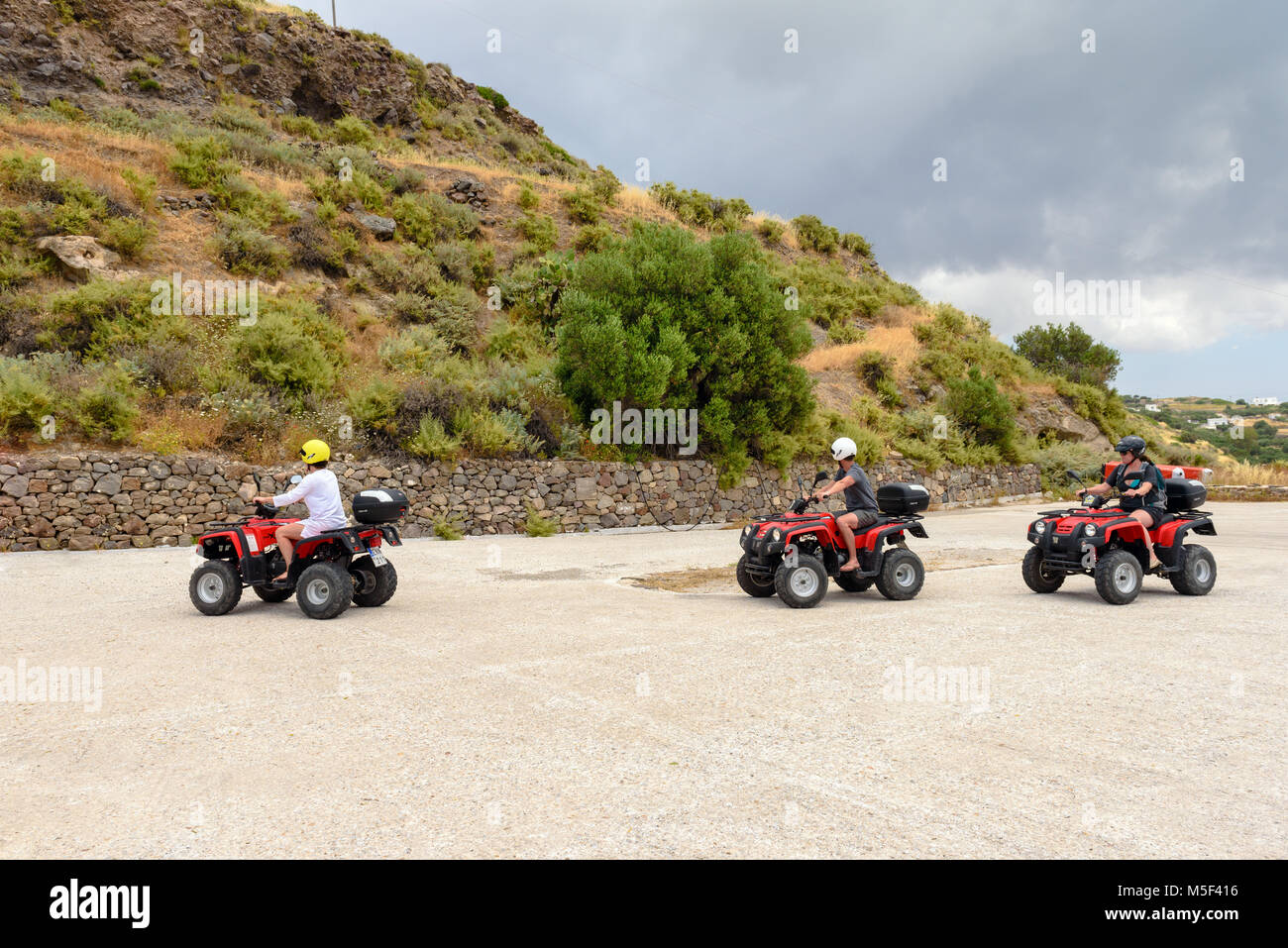Milos, Greece, May 18, 2017: Young people driving quads on road. Quad ...