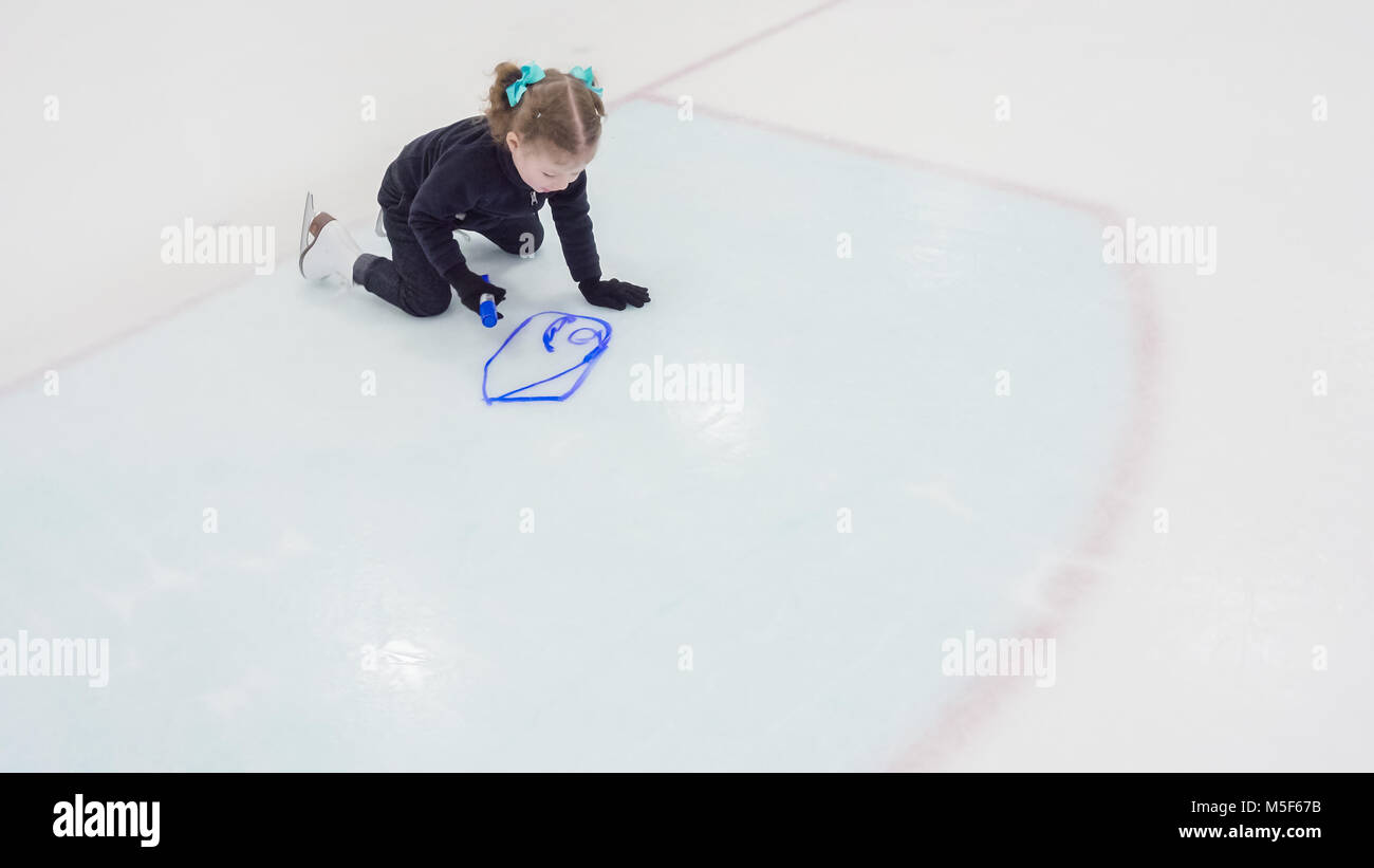 Little girl drawing with marker on ice on indorr ice skating rink Stock ...