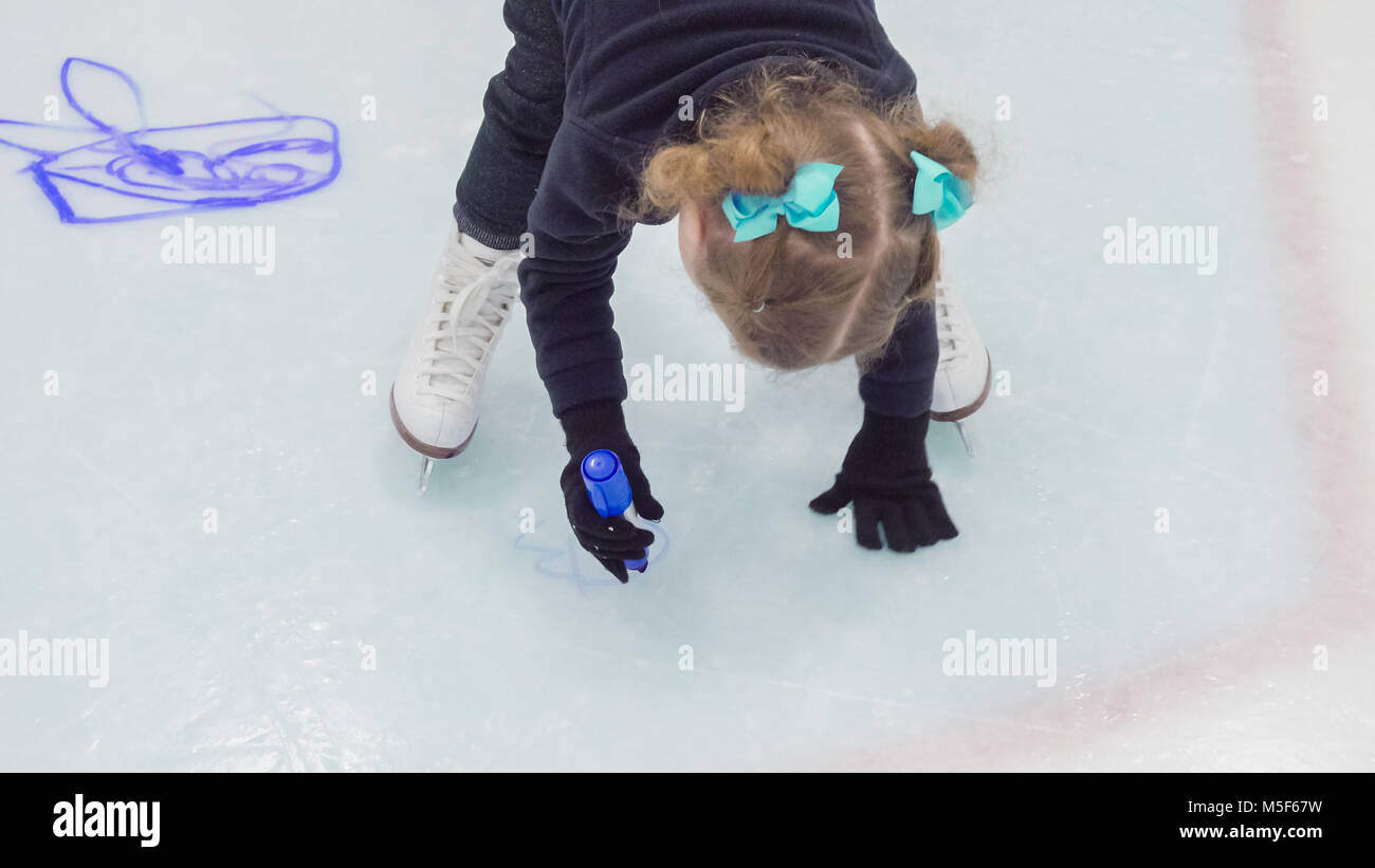 Little girl drawing with marker on ice on indorr ice skating rink Stock ...