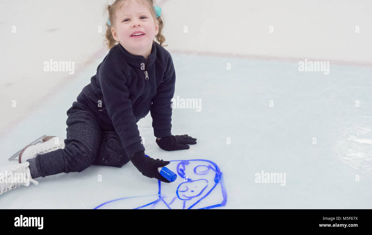 Little girl drawing with marker on ice on indorr ice skating rink Stock ...