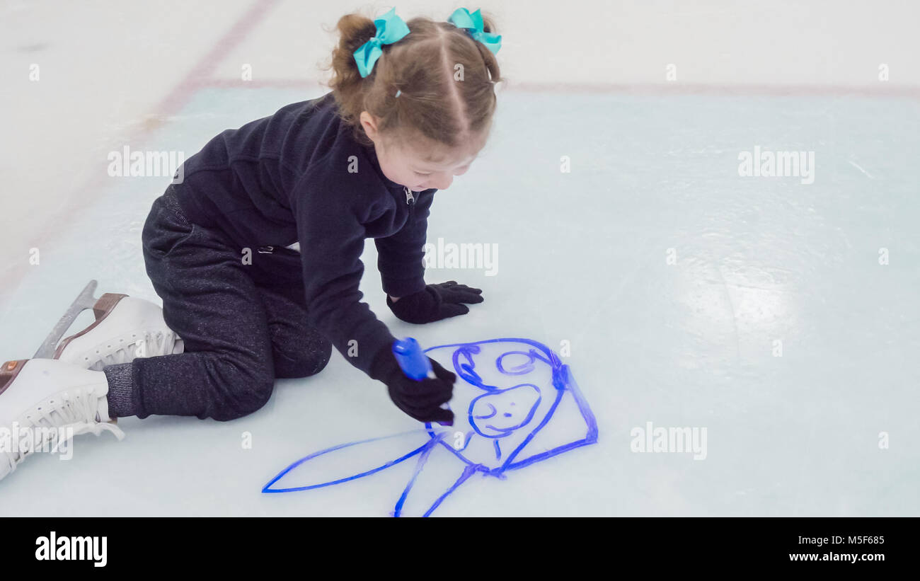 Little girl drawing with marker on ice on indorr ice skating rink Stock ...