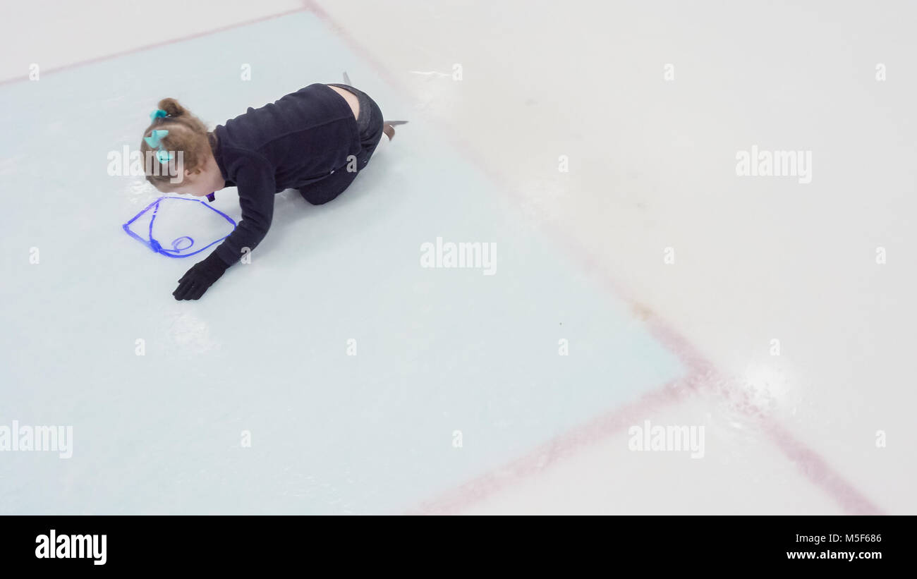 Little girl drawing with marker on ice on indorr ice skating rink Stock ...