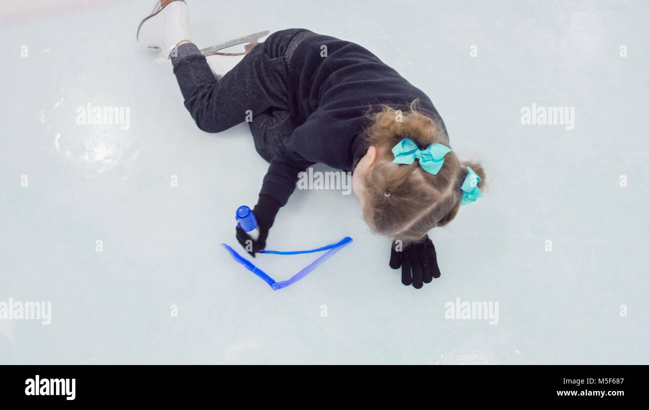 Little girl drawing with marker on ice on indorr ice skating rink Stock ...
