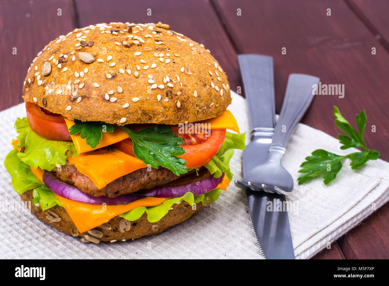 Single american burger with cheddar cheese, meat and fresh vegetables ...