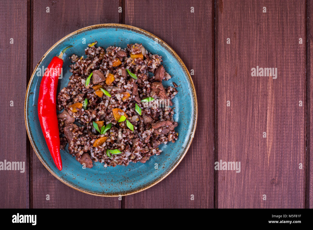 Garnish of red rice, garlic, vegetables, chicken meat. Studio Photo ...