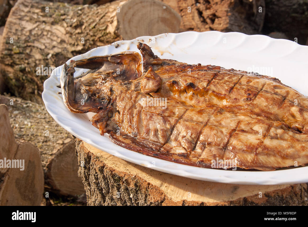 Close up view of fresh fish with sauce cooked on an open flame grill on ...