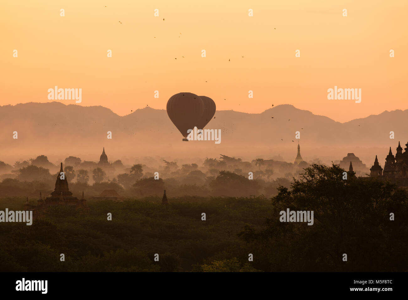 BAGAN, MYANMAR, JANUARY 2, 2018: Hot air balloon over plain of Bagan in misty morning, Myanmar ...