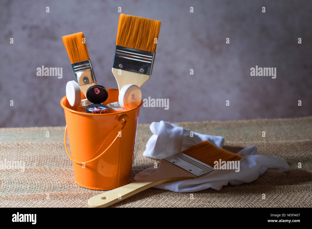 Wide paint brushes in a cute bucket on an artistic blurred background ...