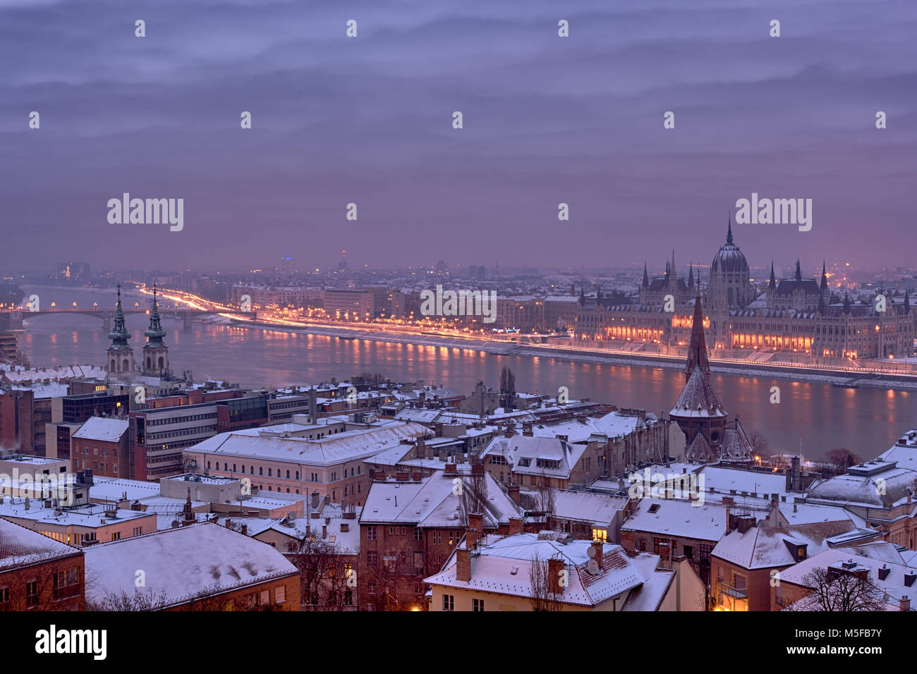 Night view of Budapest city, roofs covered with snow, river, Parliament ...