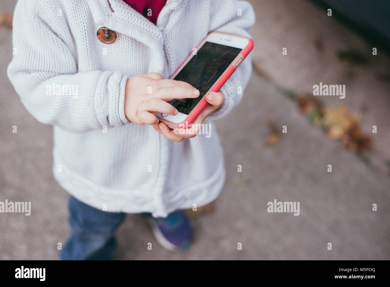 A toddler girls plays on a smartphone Stock Photo - Alamy