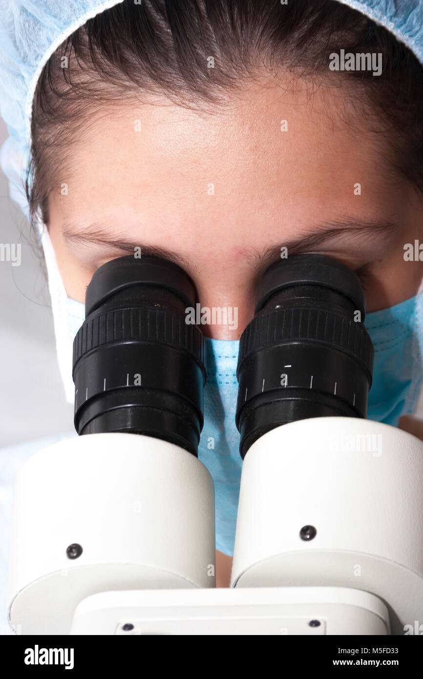 Medical professional looking through a microscope Stock Photo - Alamy