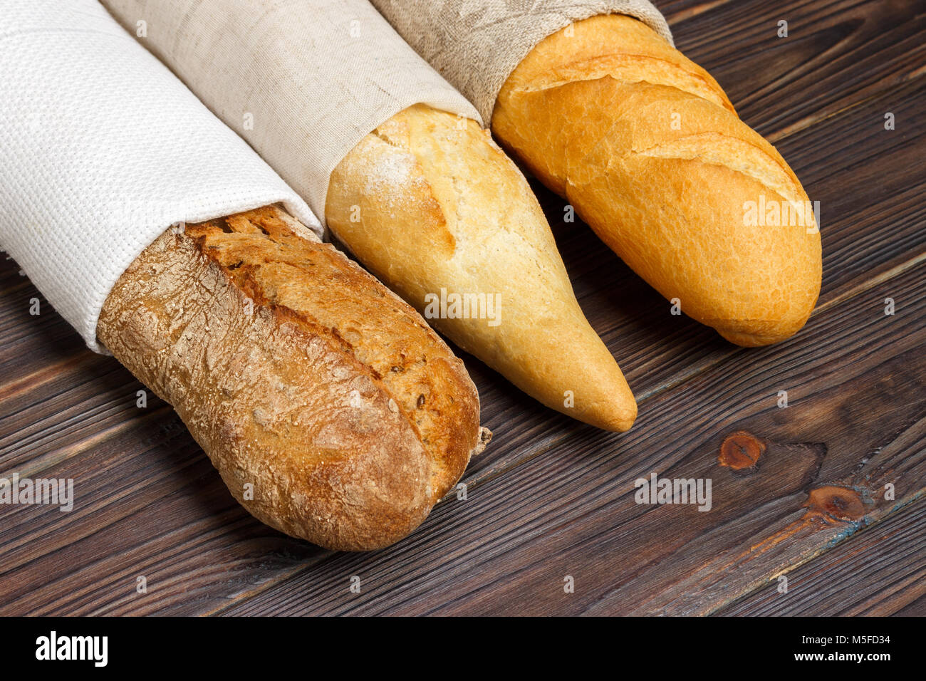 different types of baguette on a wooden background Stock Photo - Alamy