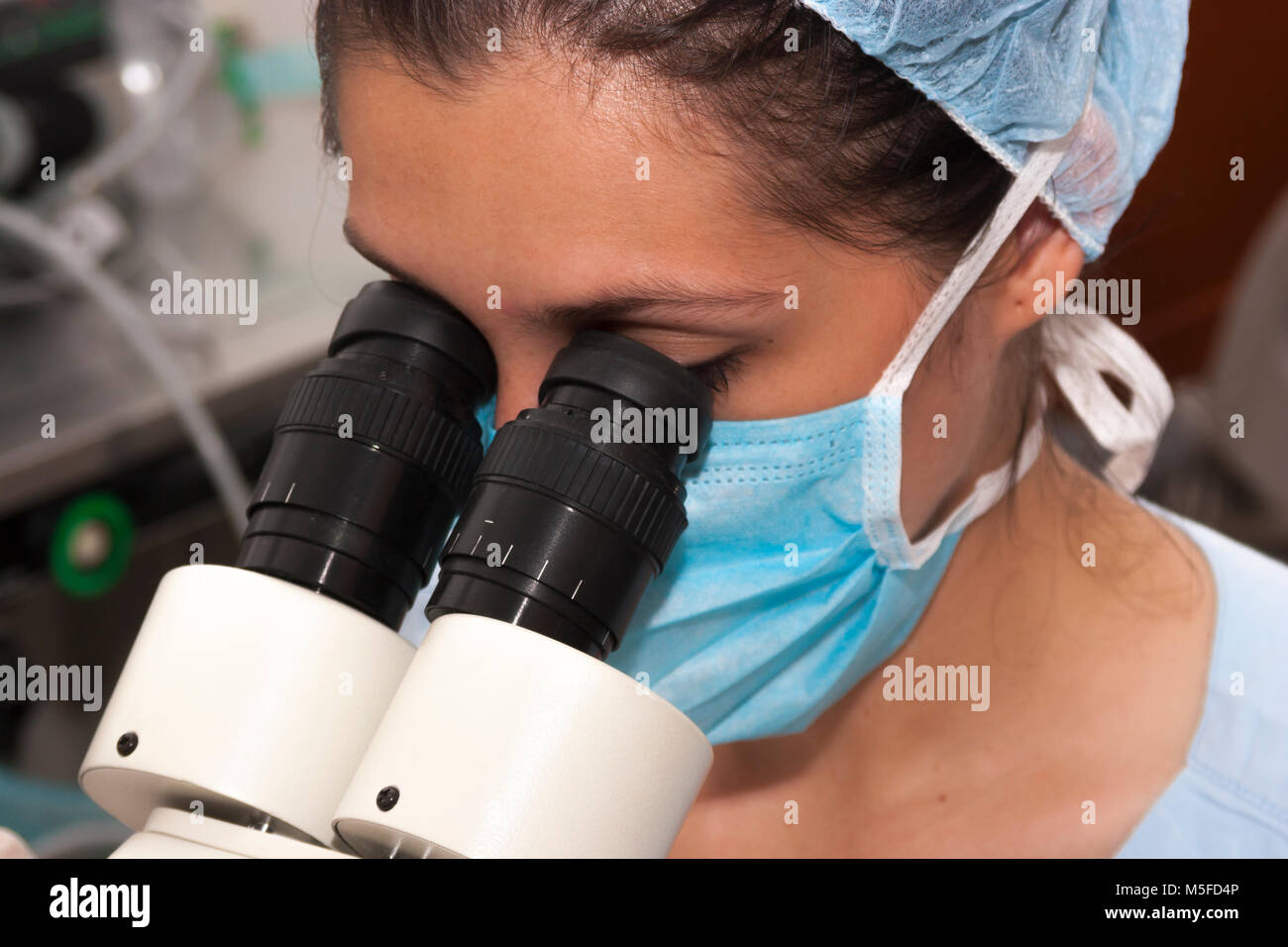 Medical professional looking through a microscope Stock Photo - Alamy