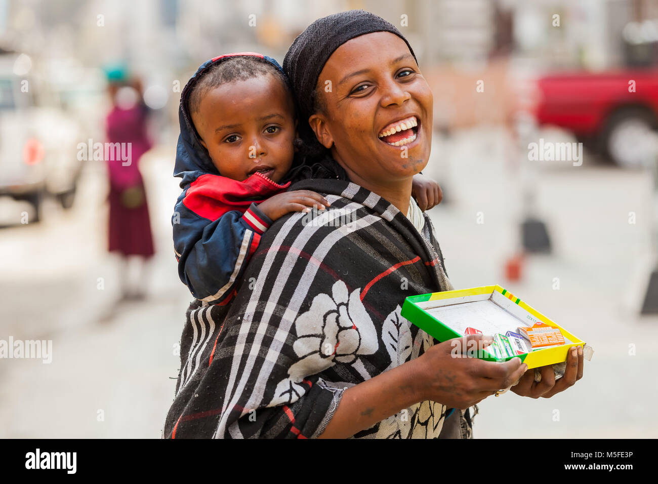 Happy African woman with child selling chewing gum on the street Stock ...