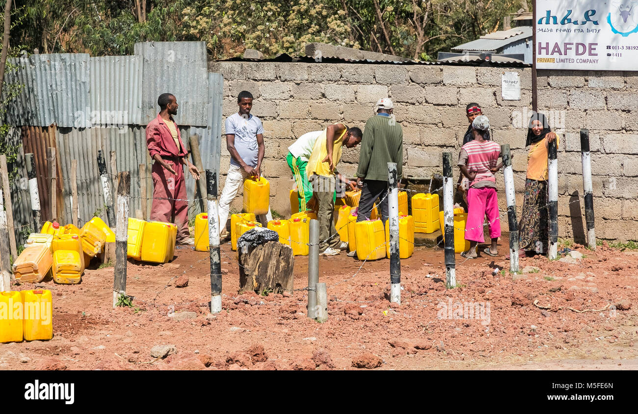 Men and women filling up barrels at a community water outlet Stock ...