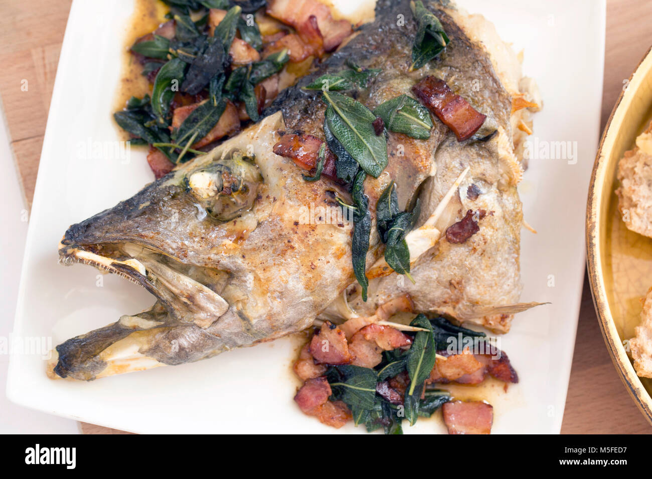 The head of a pollack caught on rod and line that has been grilled and ...