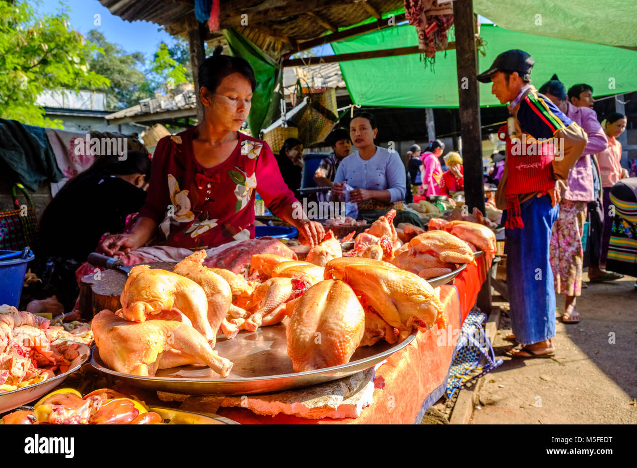 A local farmers woman is selling chicken meat in the street market of ...
