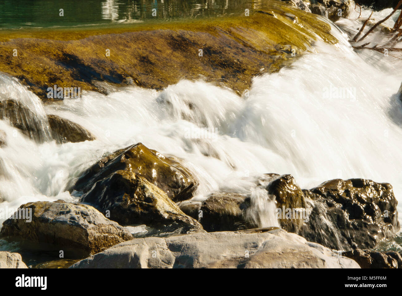 Natural background of flowing water in the golden river Stock Photo - Alamy
