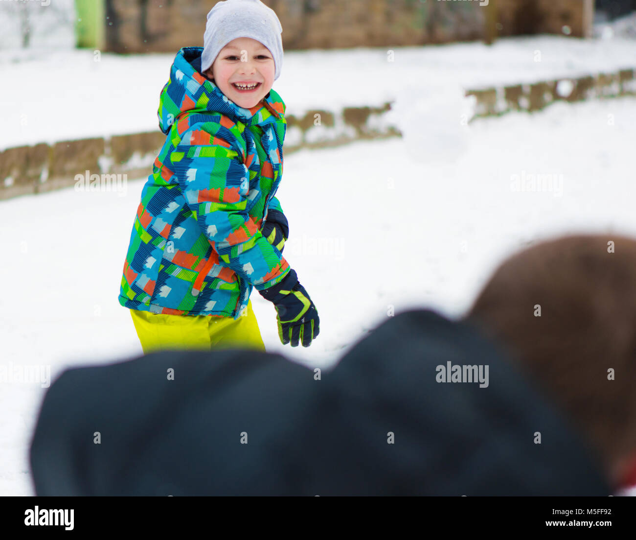 Children throwing snowballs in snowy winter park Stock Photo - Alamy