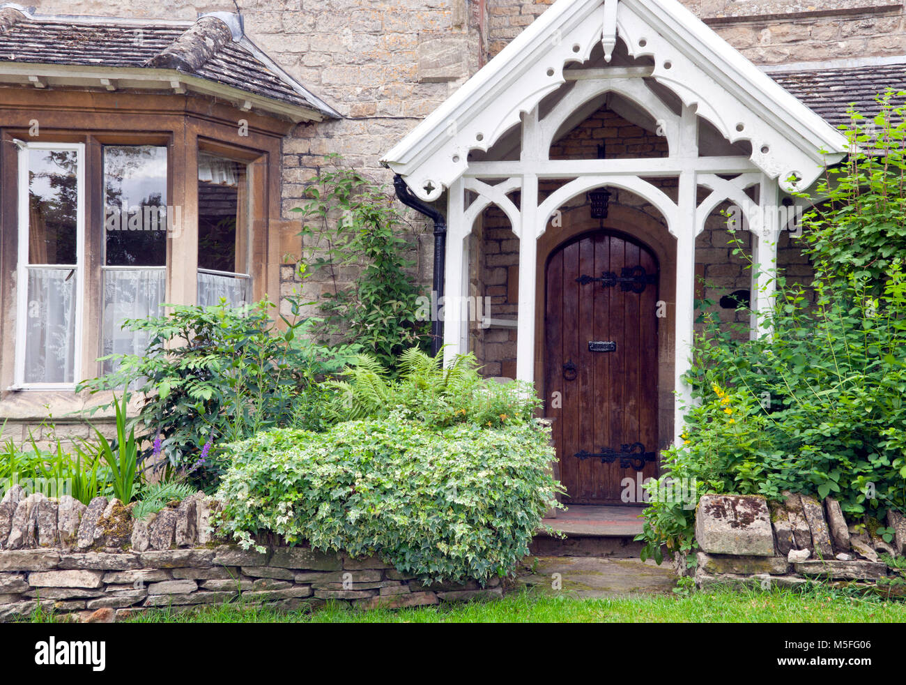 Dark brown wooden doors in an old traditional English stone house with ...