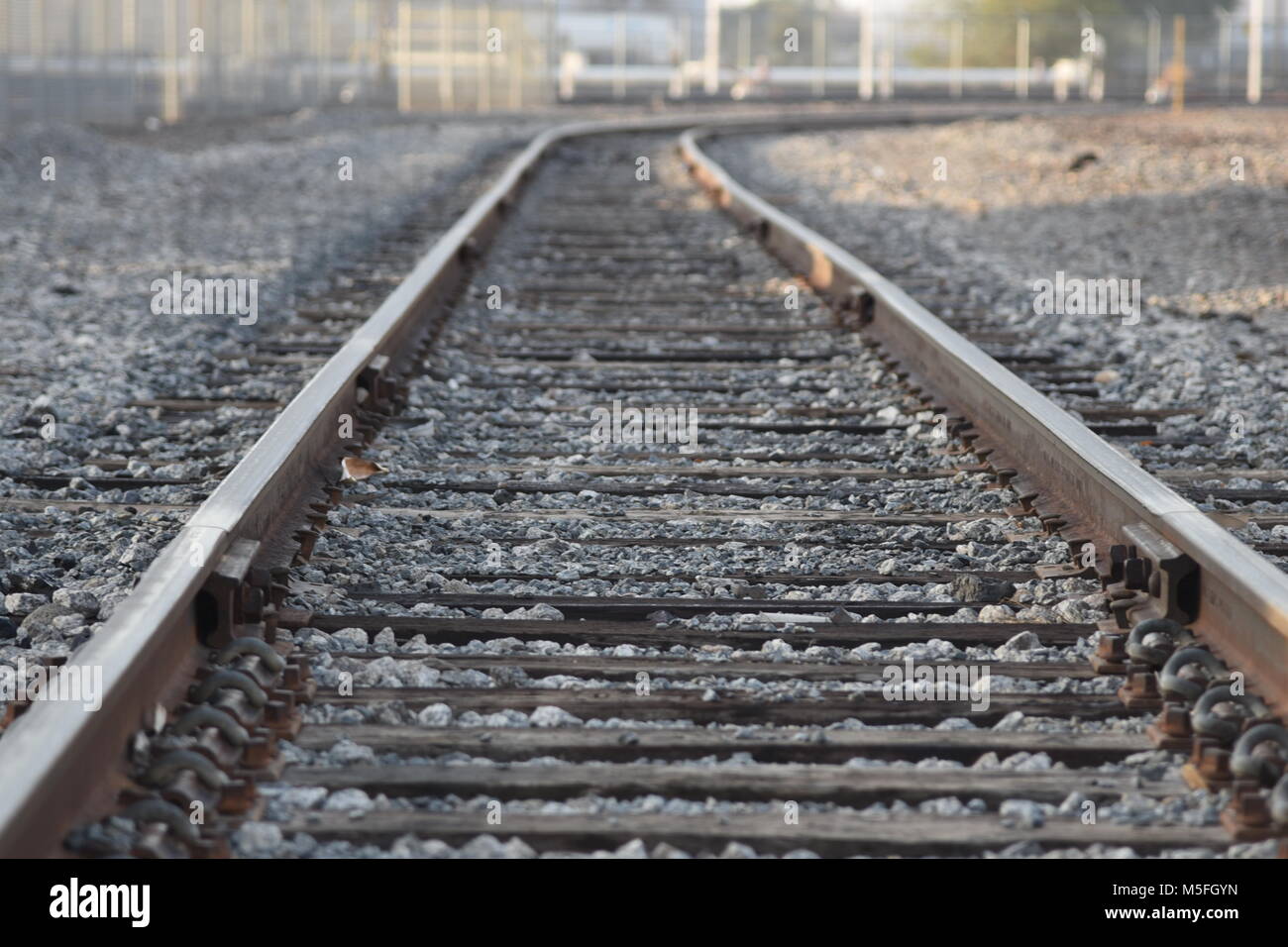 Railroad tracks bending right in distance Stock Photo - Alamy
