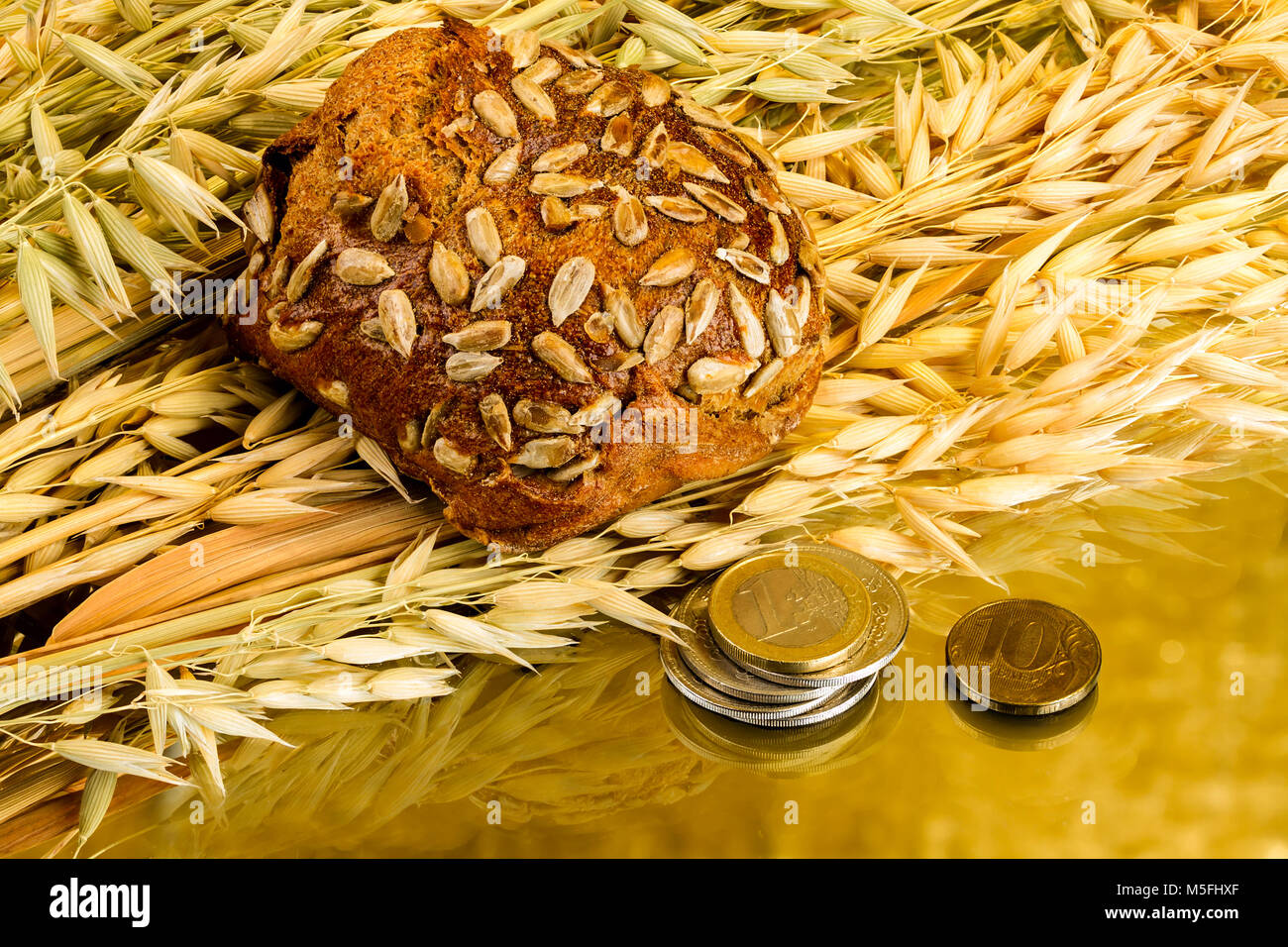 fresh white bread and coins on golden background Stock Photo - Alamy