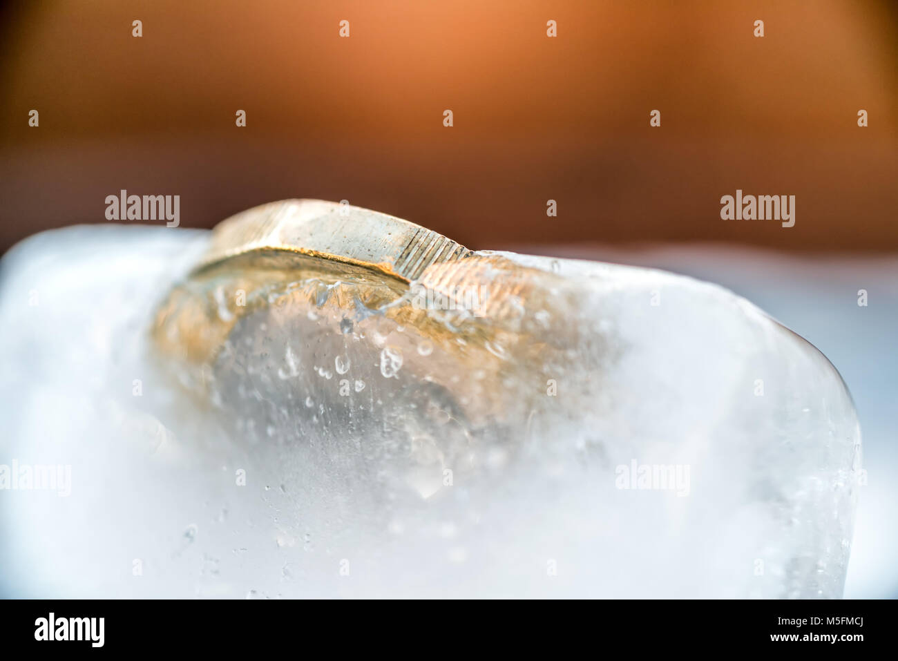 Frozen New British one pound sterling coin up close macro inside ice ...