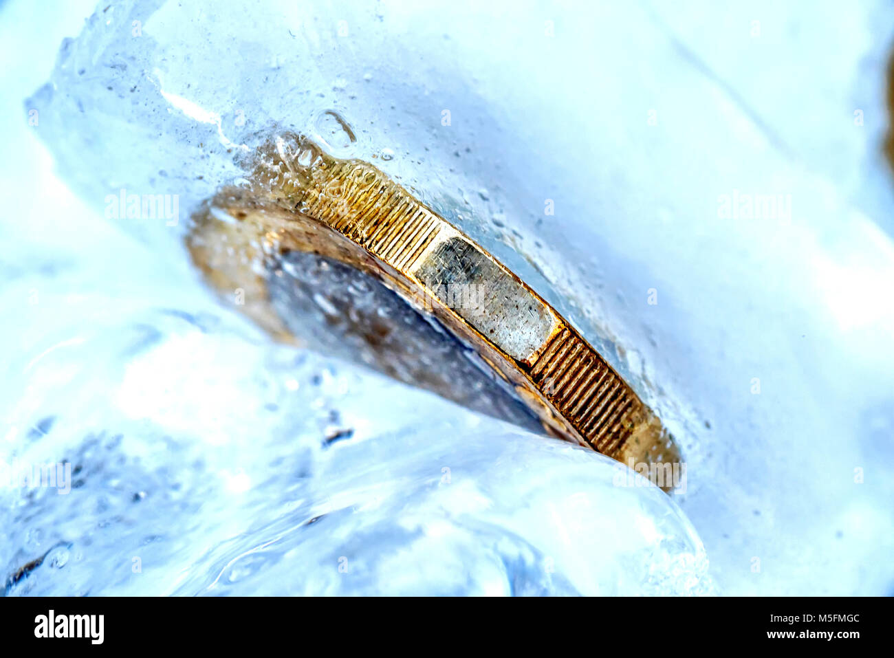 Frozen New British one pound sterling coin up close macro inside ice ...