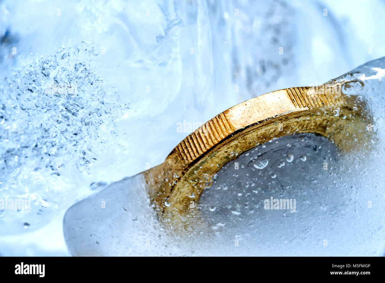 Frozen New British one pound sterling coin up close macro inside ice ...