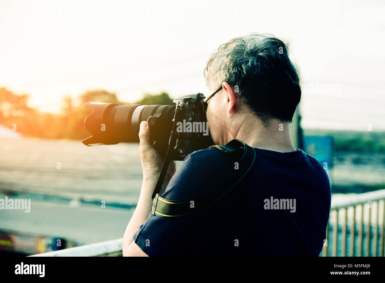 Man using camera DSLR taking photo sunlight background Stock Photo - Alamy