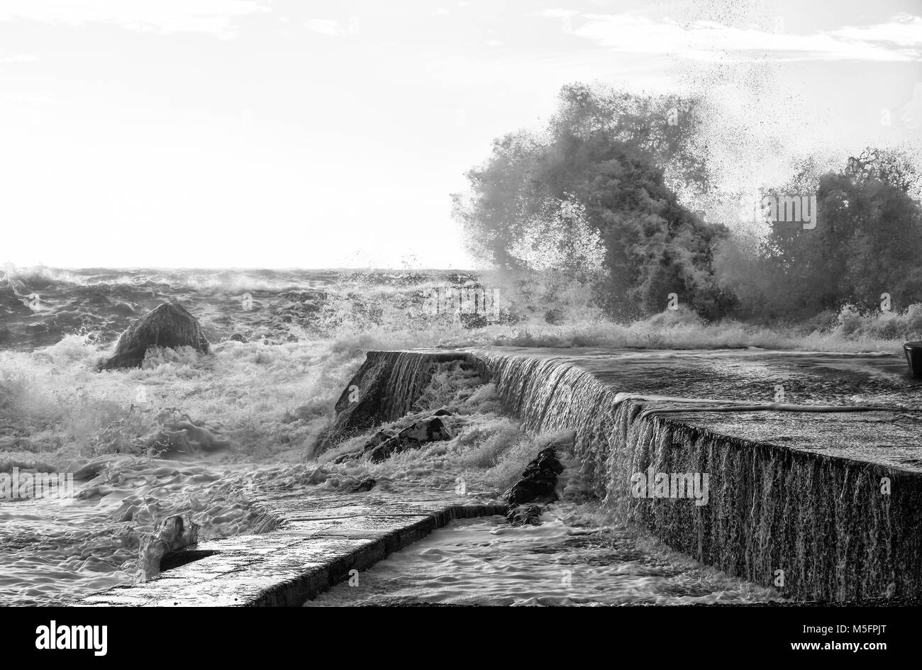 A big wave crashes into the pier/ wave/ water/ storm Stock Photo - Alamy