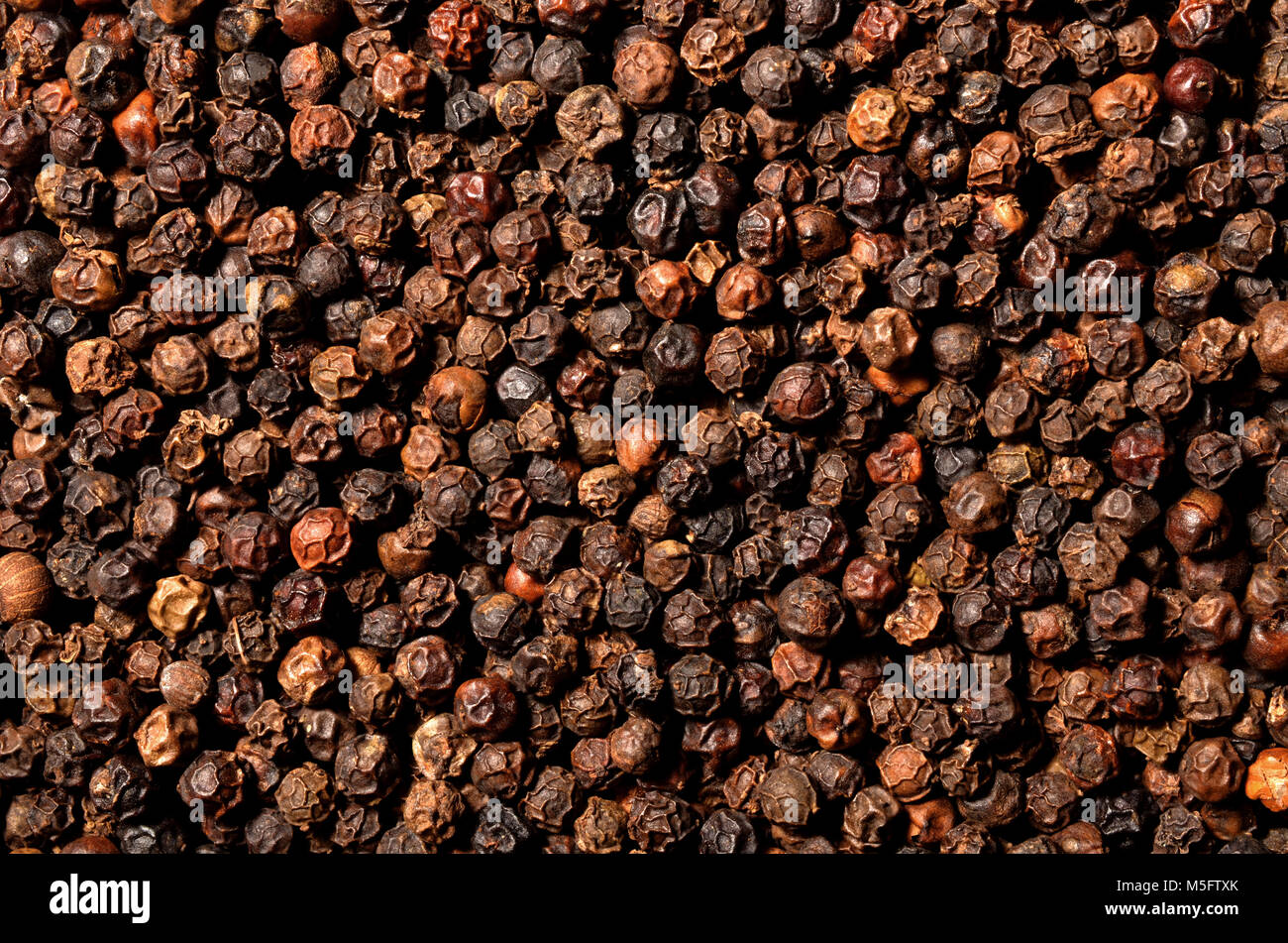 Dried black pepper grain pile, a top view closeup photo on surface of ...