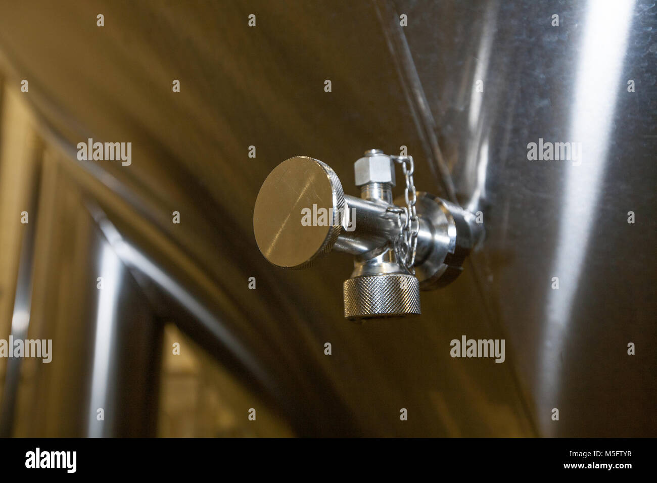 Valves and pipes made of white metal, located on the tanks, which ...