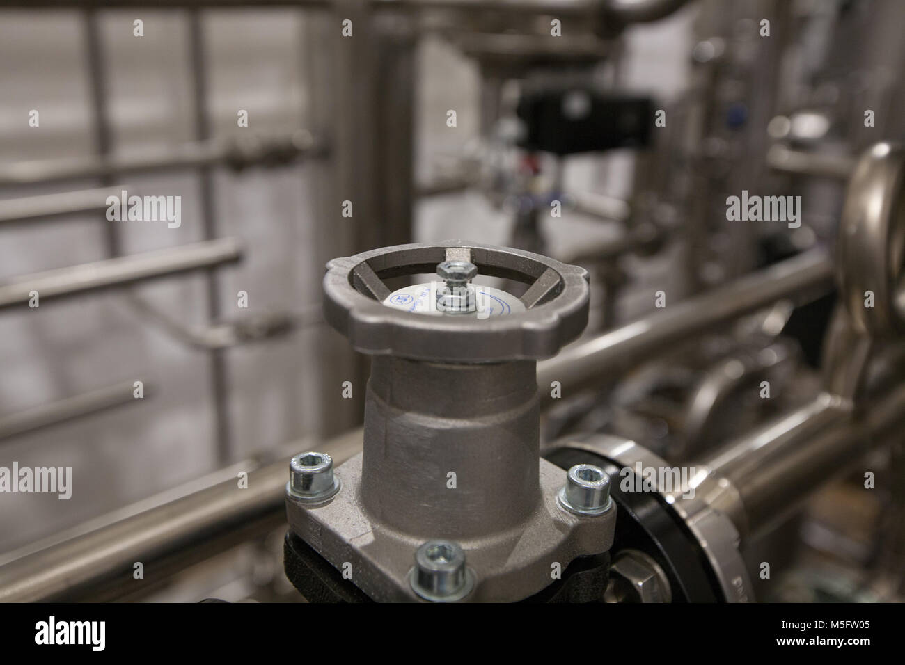 Valves and pipes made of white metal, located on the tanks, which ...