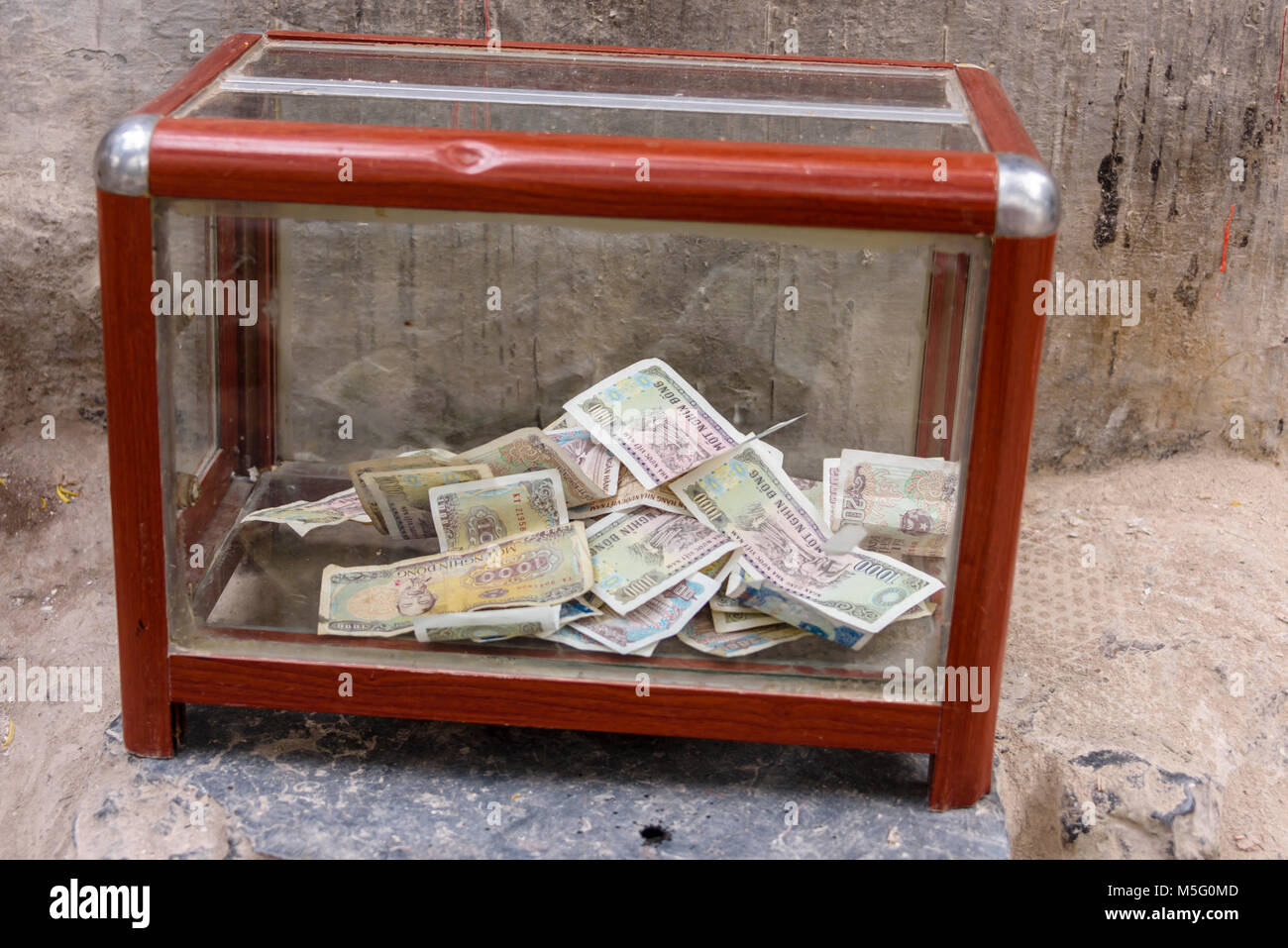 Money is left in a glass collection box outside the Den Ngoc Son ...