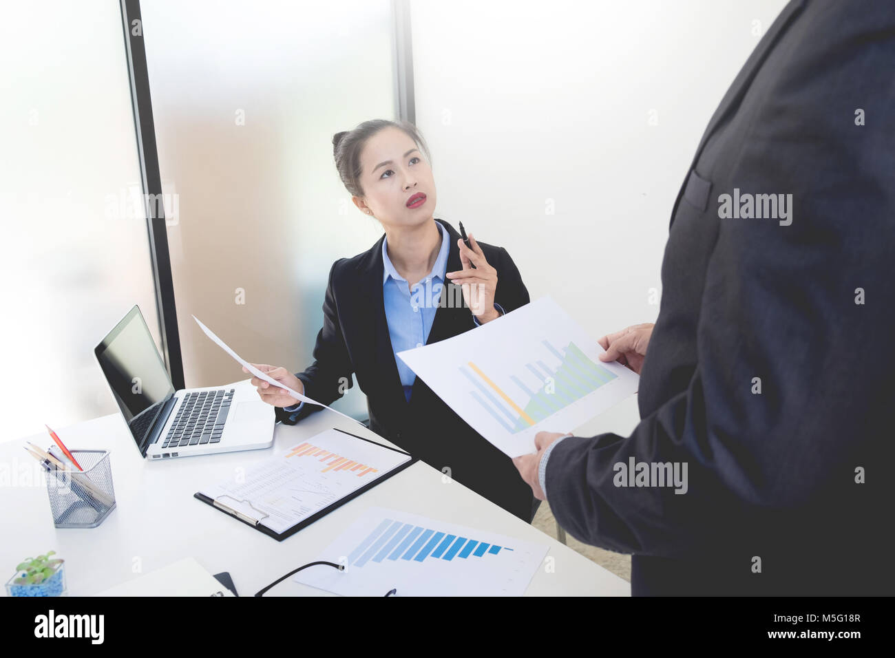 Active woman Manager explaining colleagues latest profit financial data ...
