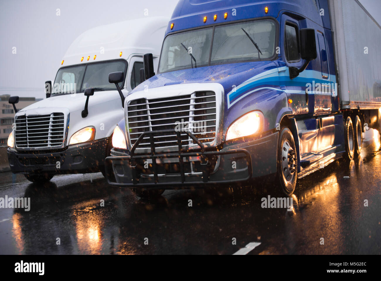 Heavy traffic with big rig semi trucks convoy going side by side with ...
