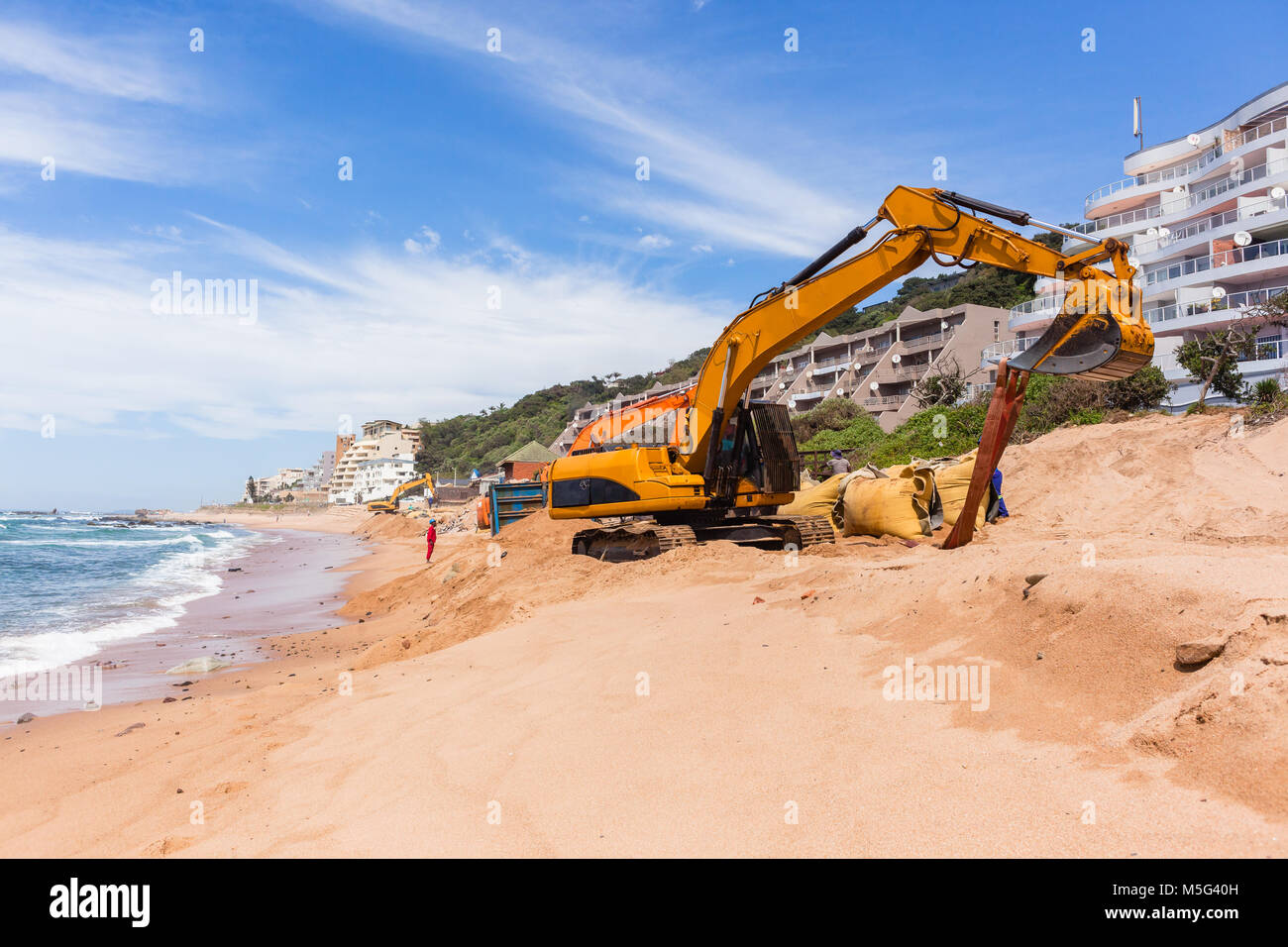 Construction excavators machines on beach water line coastline building ...