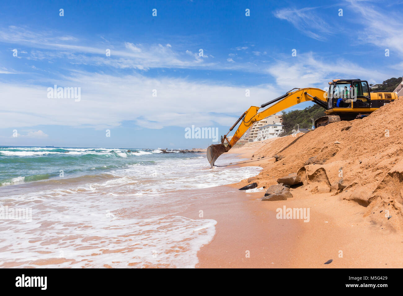 Construction excavators machines on beach water line coastline building ...