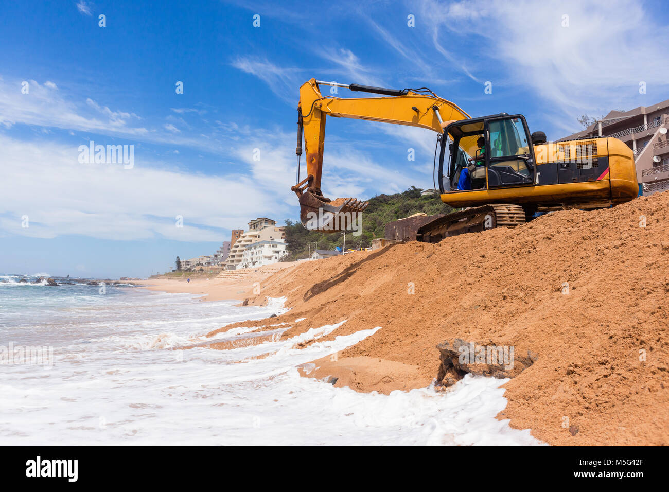 Construction excavators machines on beach water line coastline building ...