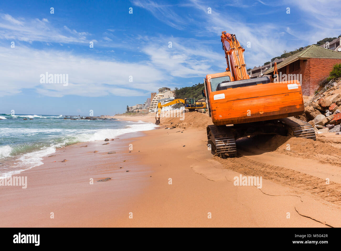 Construction excavators machines on beach water line coastline building ...