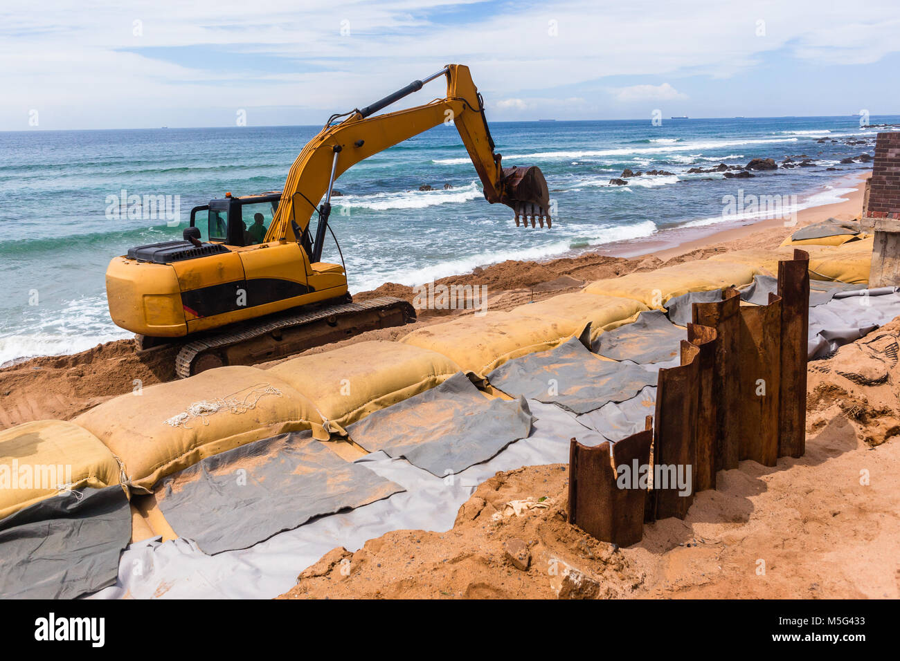 Construction excavators machines on beach water line coastline building ...