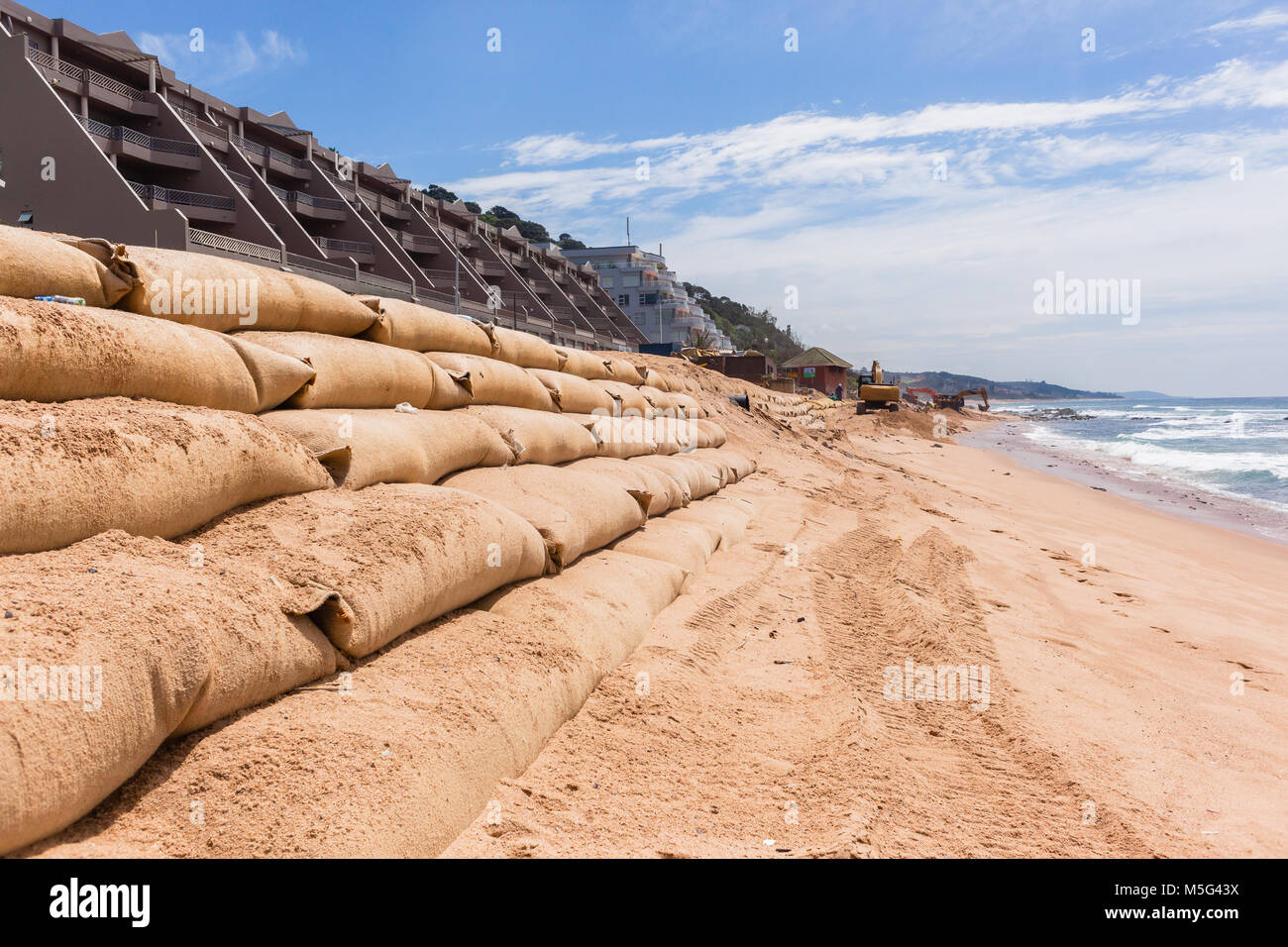 Construction excavators machines on beach water line coastline building ...