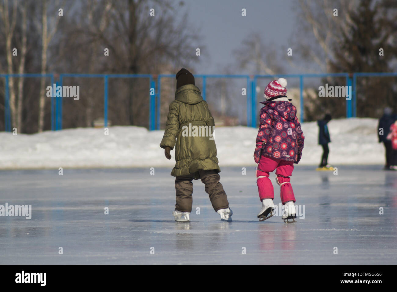 Two little girls on ice-rink - children's skating sport Stock Photo - Alamy