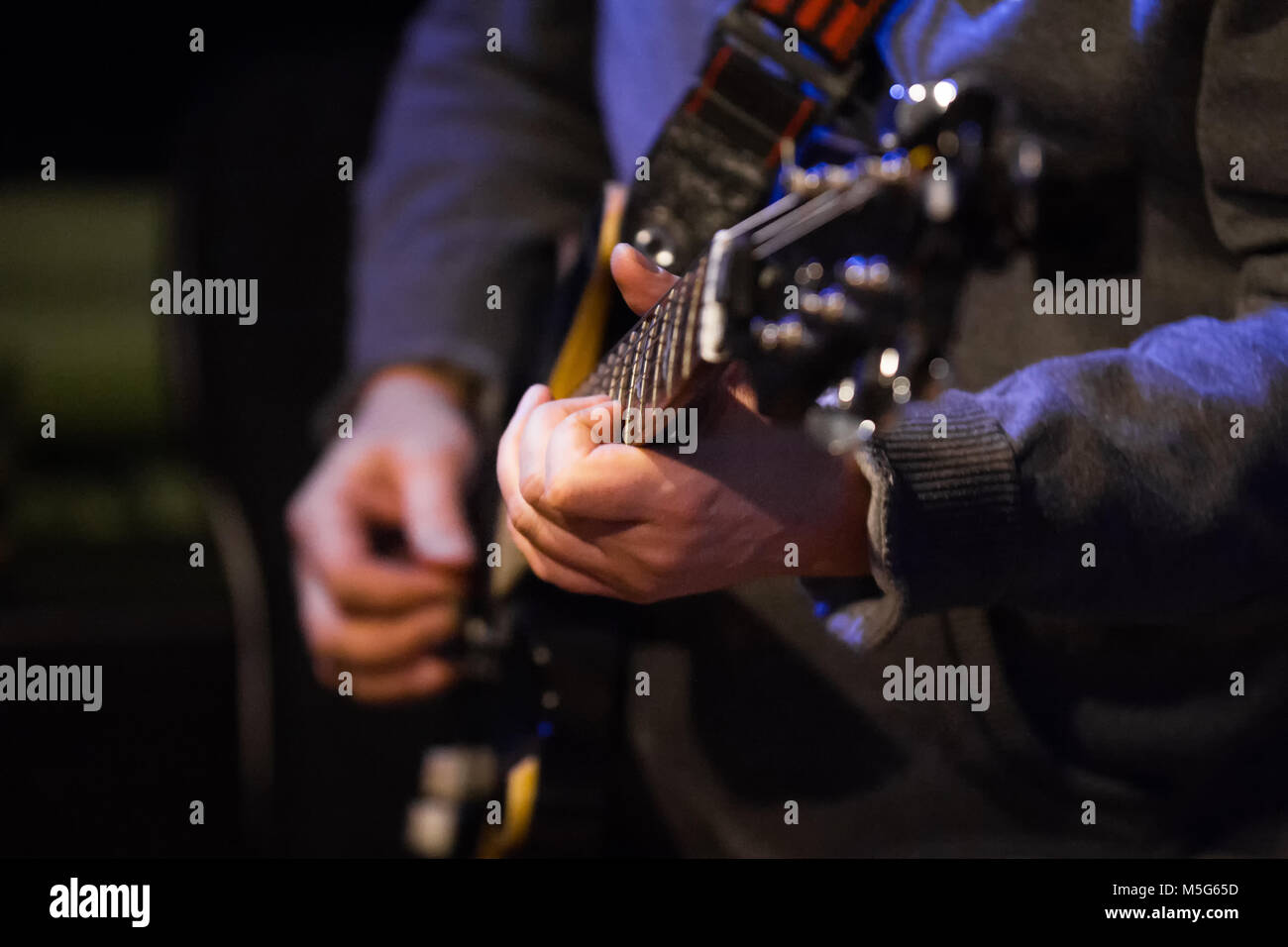Musician in night club - guitarist holding soundboard electric guitar ...