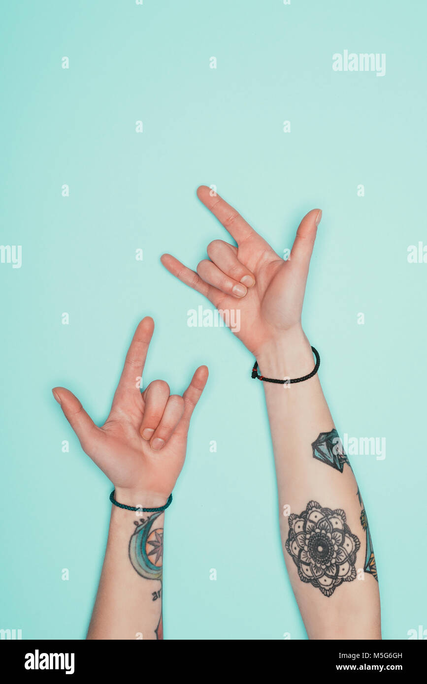 cropped shot of woman showing horns signs with hands isolated on ...